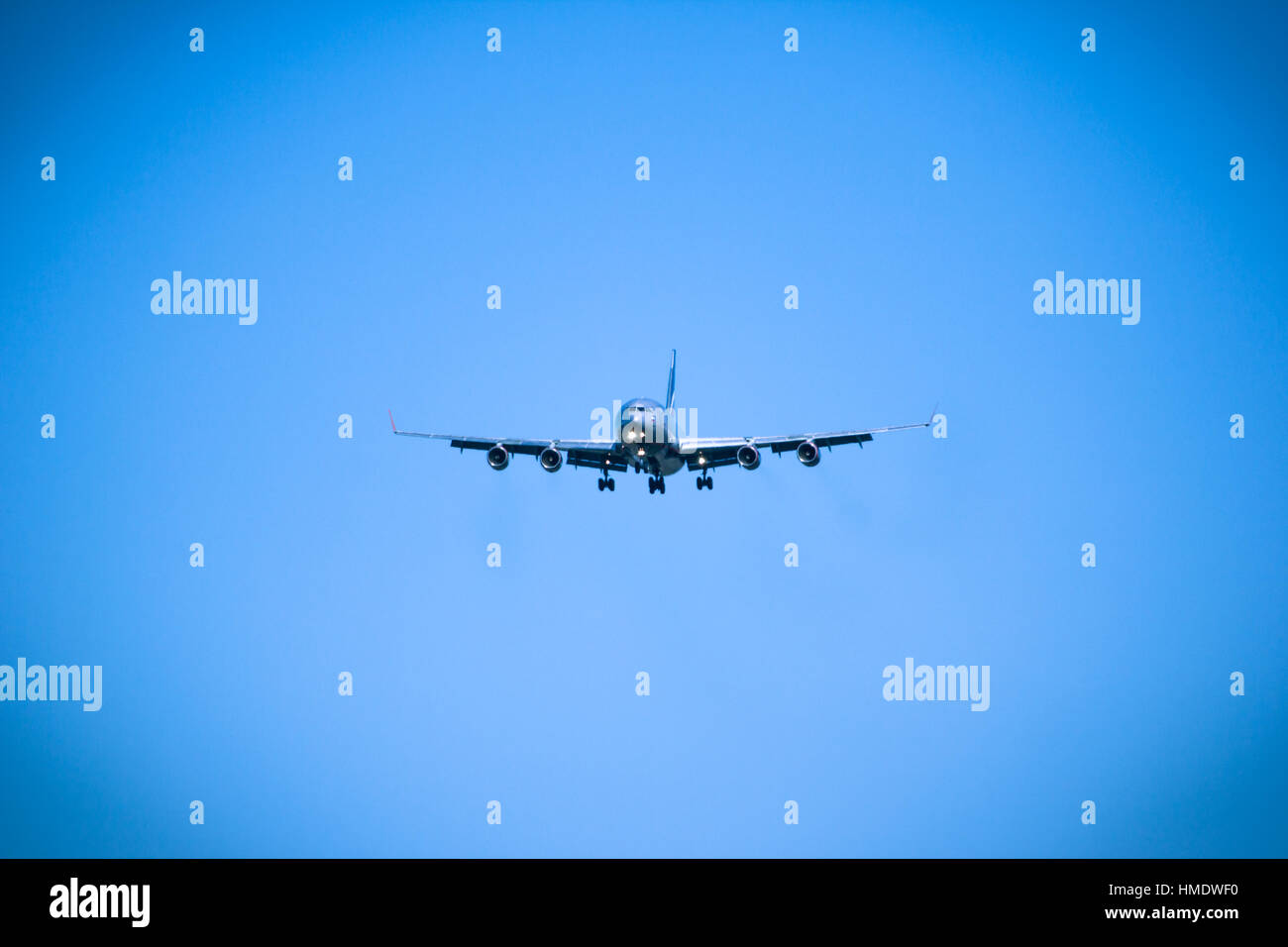 Jet airplane flying overhead close-up on a blue sky background Stock ...
