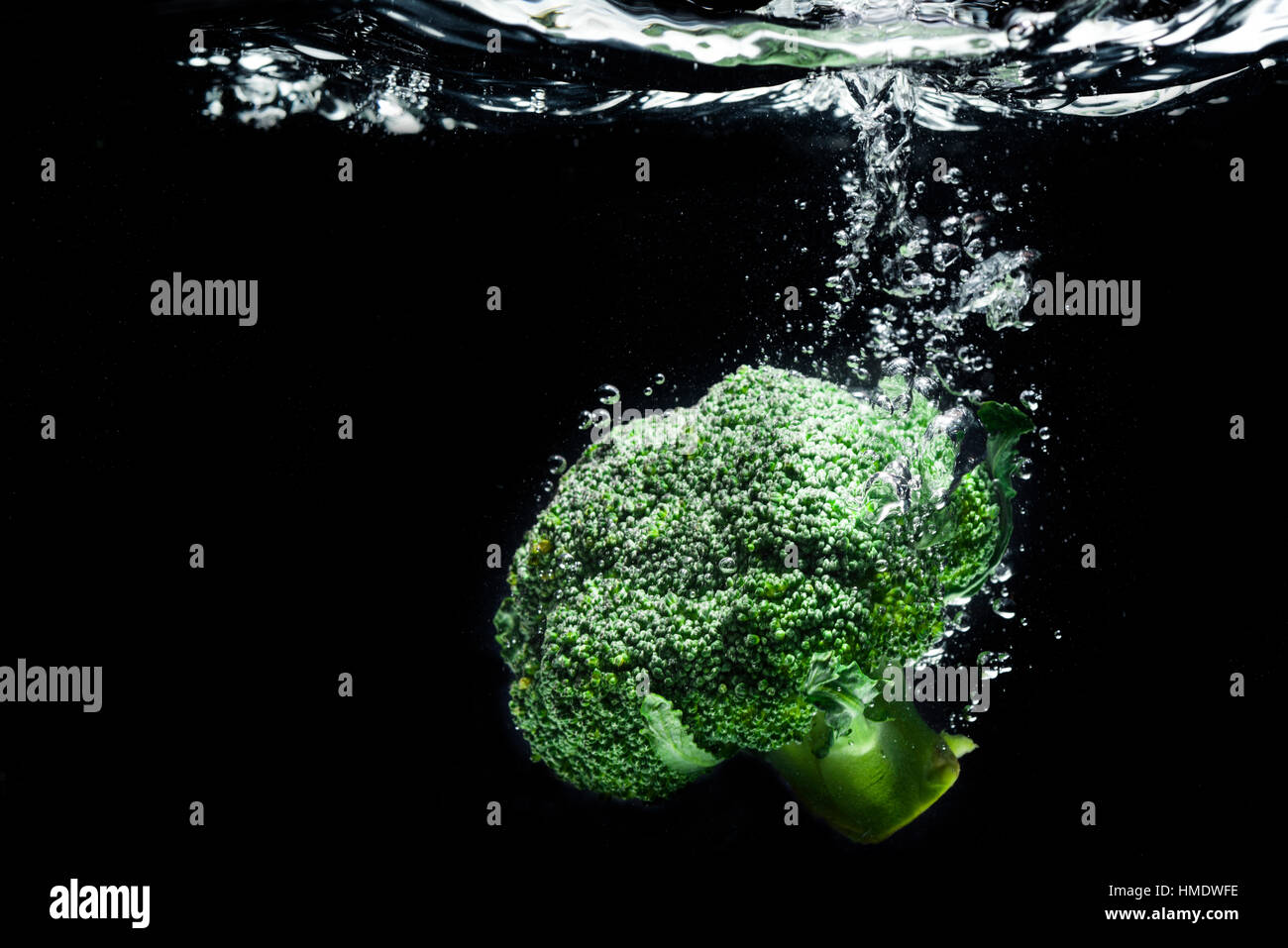 Fresh broccoli in water isolated on black background Stock Photo - Alamy