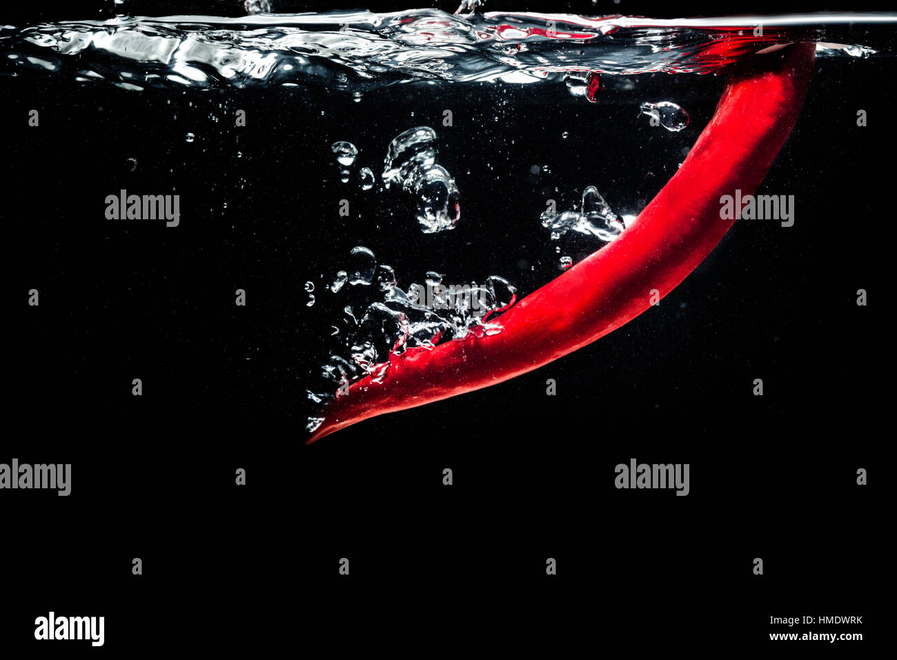 Chili in water splash isolated on the black background Stock Photo - Alamy