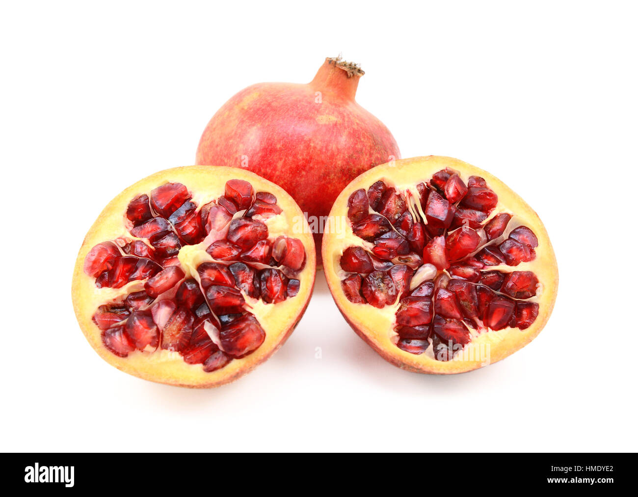 Whole red pomegranate and two cut halves showing seeds, isolated on a ...