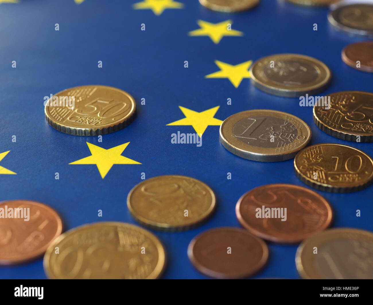 Euro coins (EUR), currency of European Union over flag of Europe Stock ...