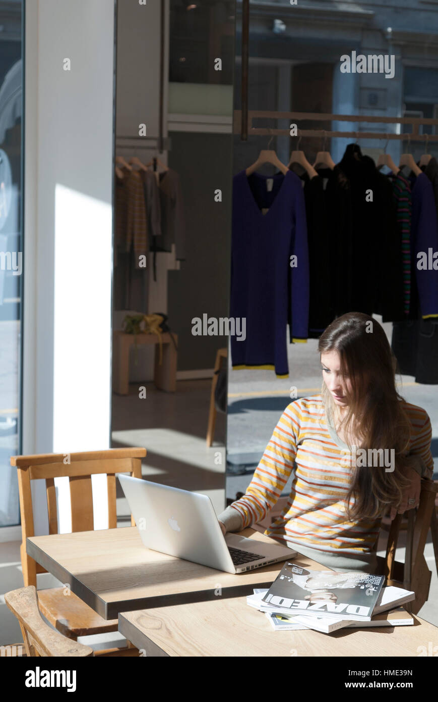 Young beautiful italian girl seated in a coffee boutique shop having a ...