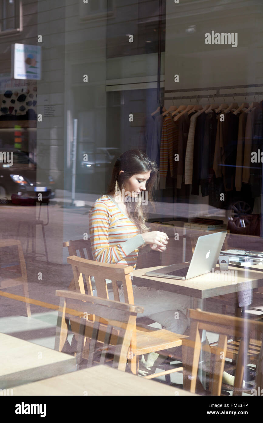 Young beautiful italian girl seated in a coffee boutique shop having a ...