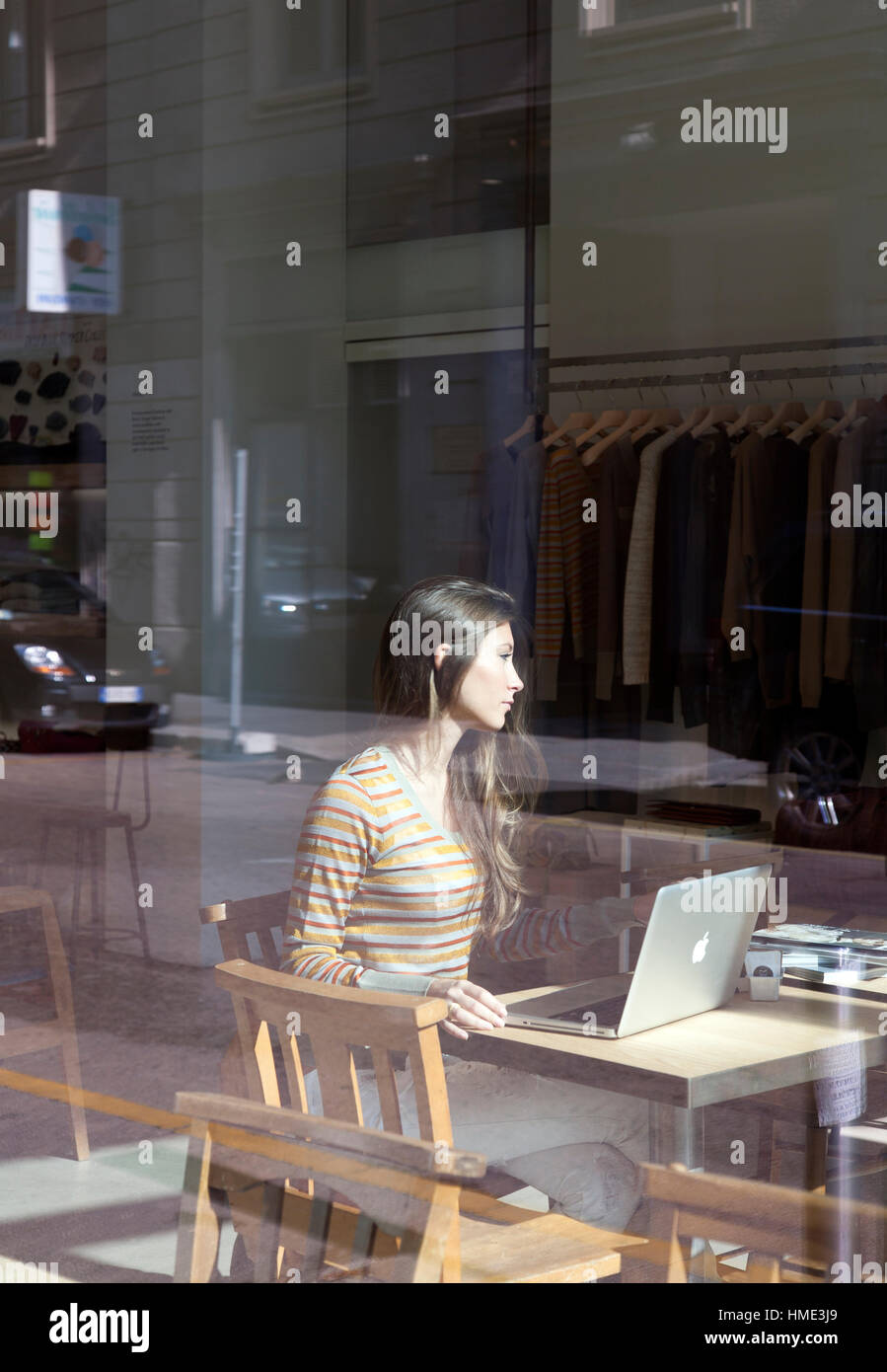 Young beautiful italian girl seated in a coffee boutique shop having a ...