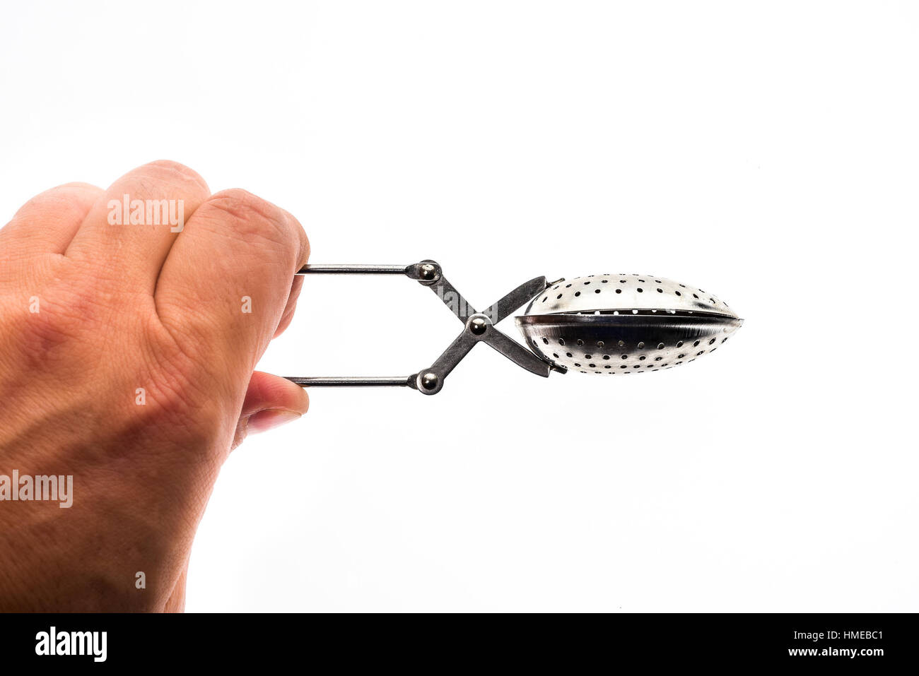 Hand holding tea strainer clamp on the white background. Kitchen ...