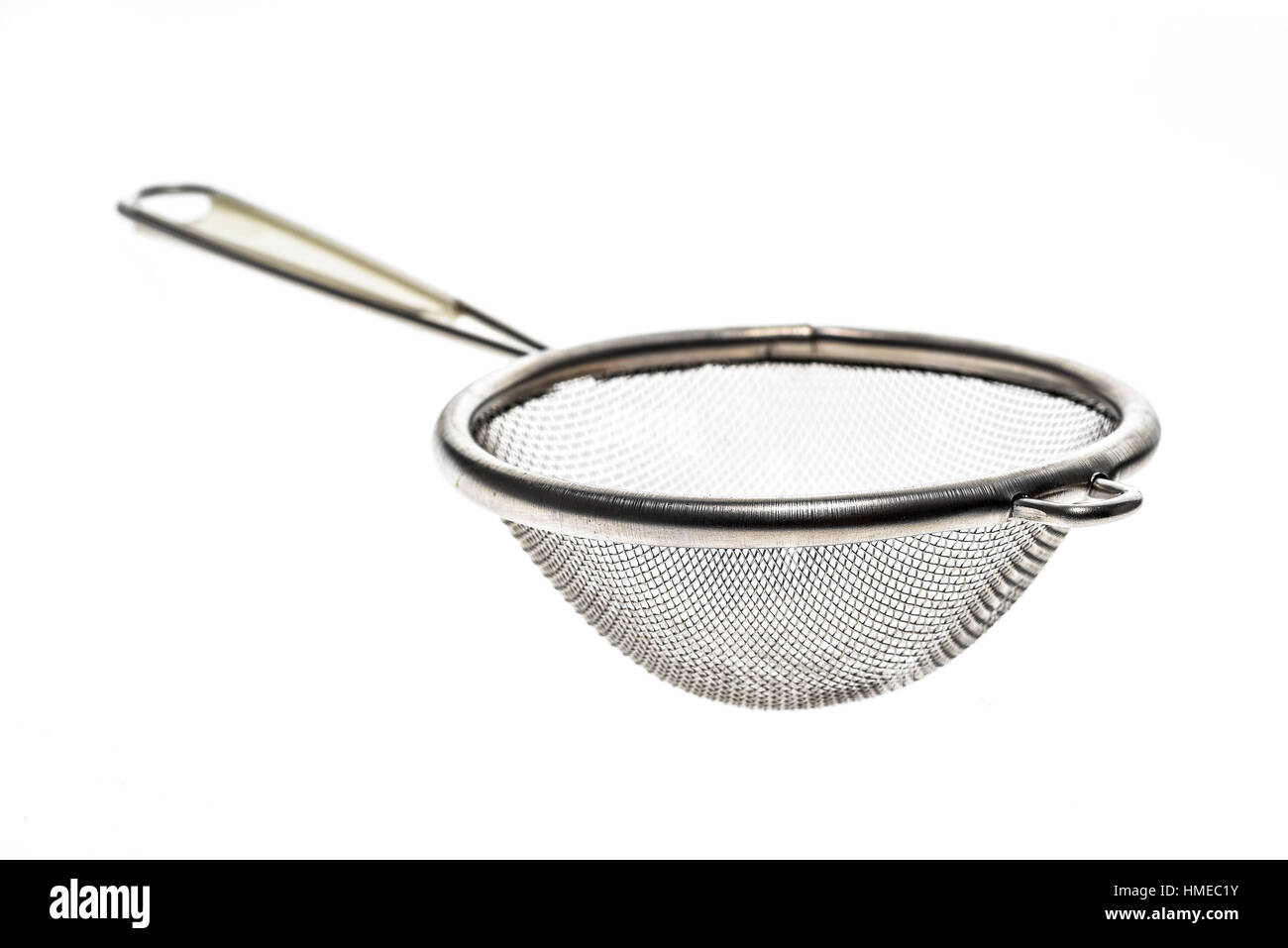 Small metallic tea strainer sieve with handle isolated on white. Modern ...