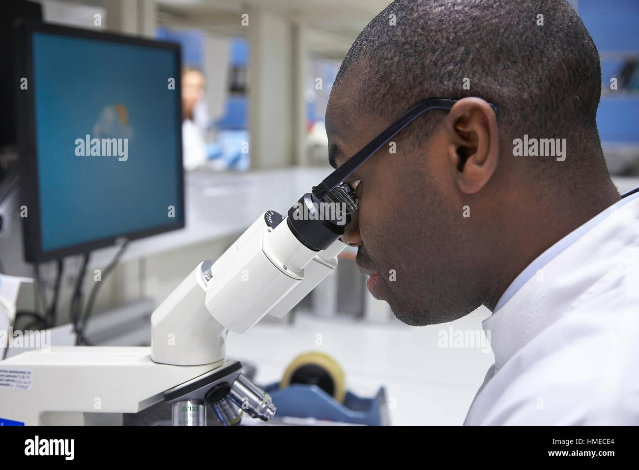 Black man looking through microscope hi-res stock photography and ...