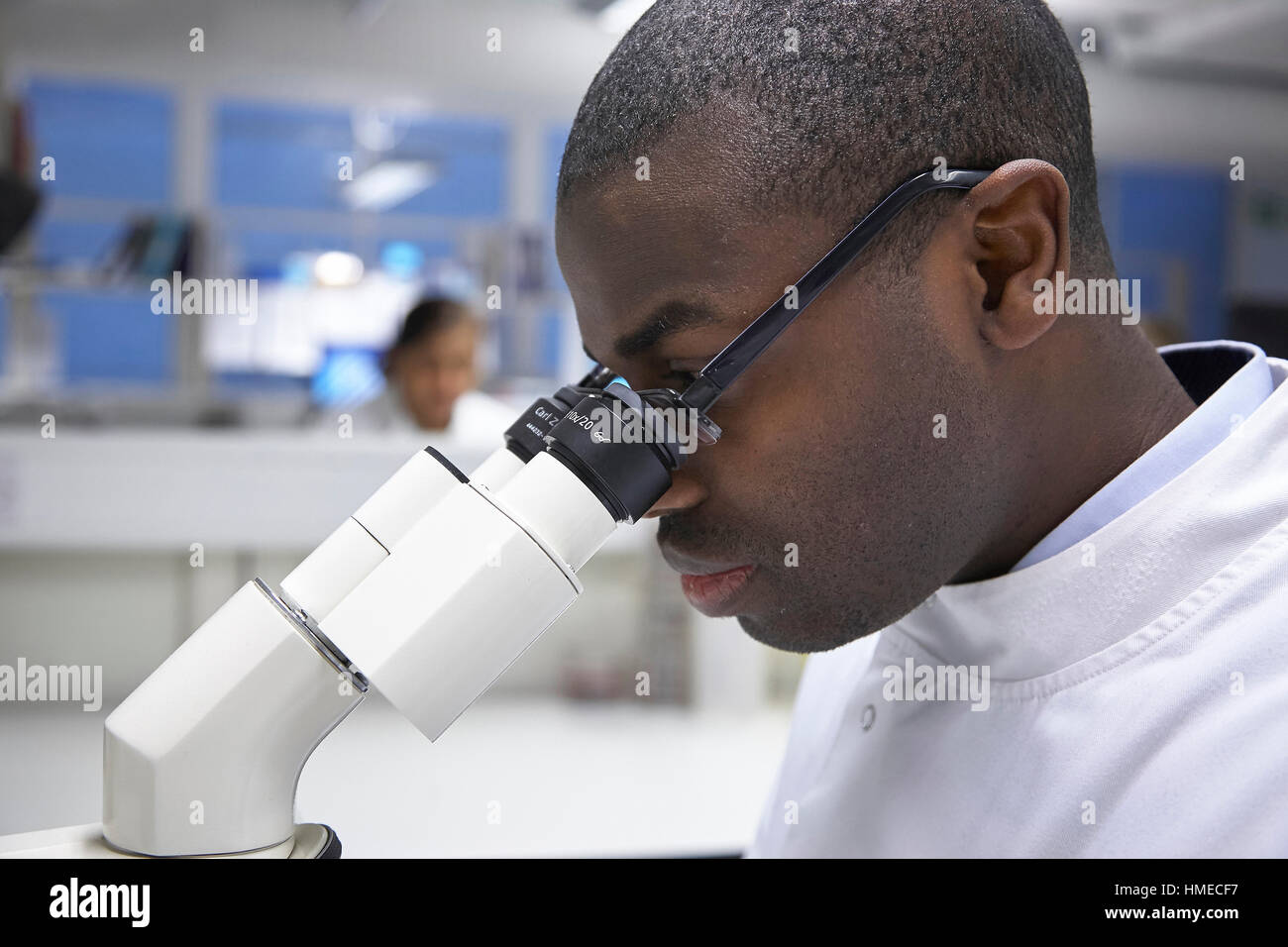 Black man looking through microscope hi-res stock photography and ...