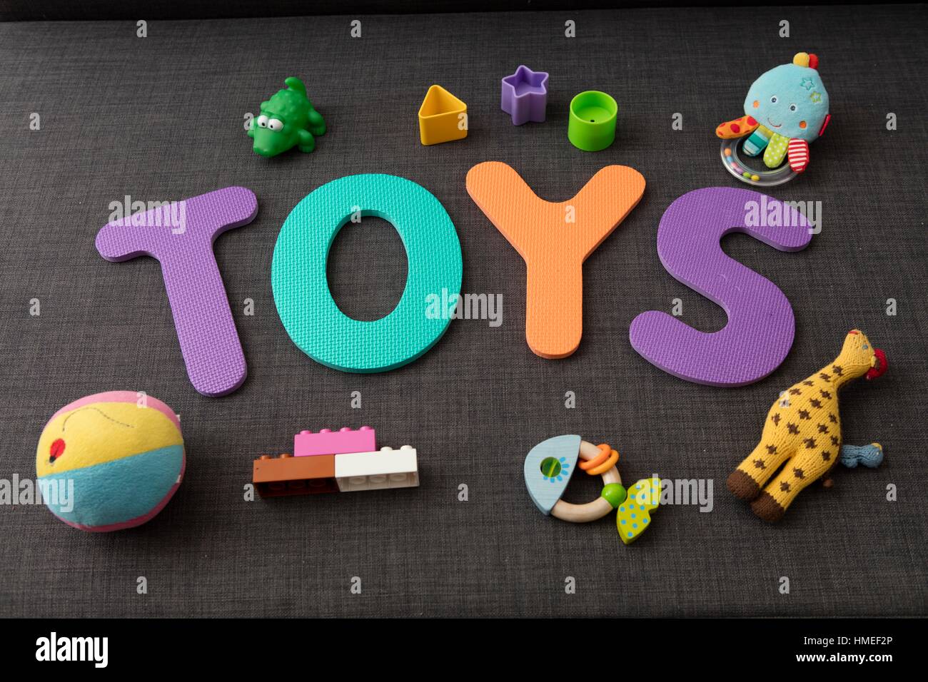 The word TOYS of a children´s mat with a selection of toys on a dark ...