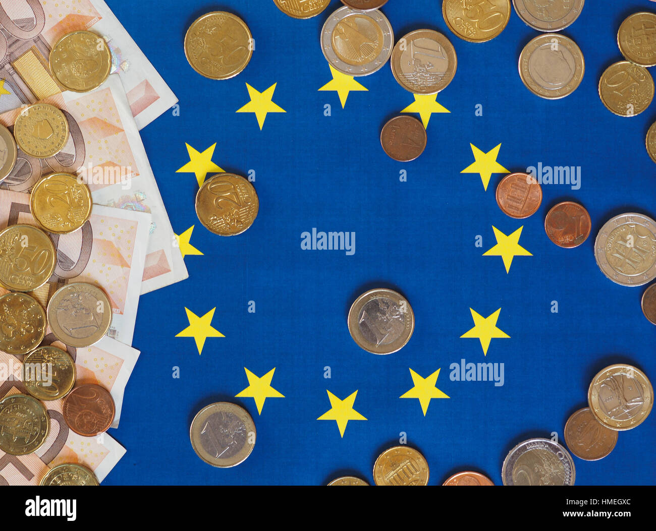 Euro banknotes and coins (EUR), currency of European Union over flag of ...