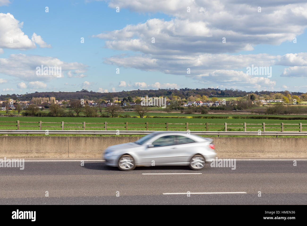 Speeding car on the motorway with countryside and village in the ...