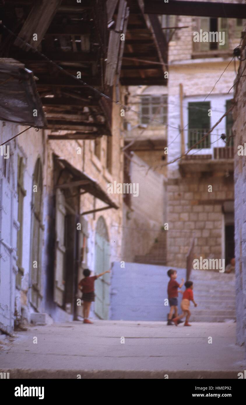 Israeli children playing in an alleyway lined with balconies behind the ...
