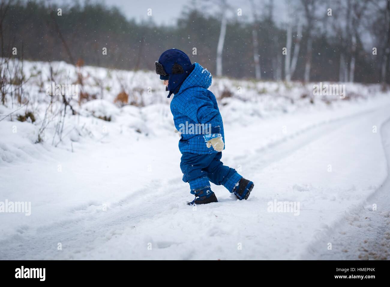 Happy little boy playing outdoor in winter snow. Snowy weather and ...