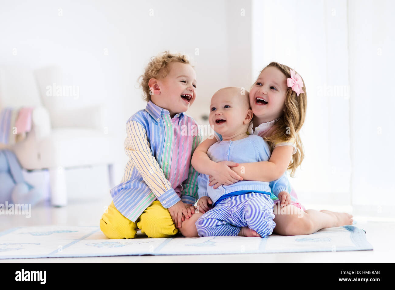 Group of three kids playing in a white bedroom. Children play at home ...