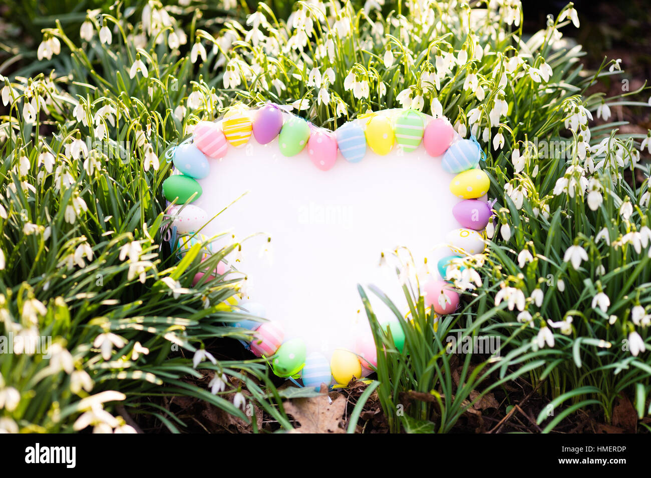 Beautiful white board in heart shape decorated with pastel color Easter ...