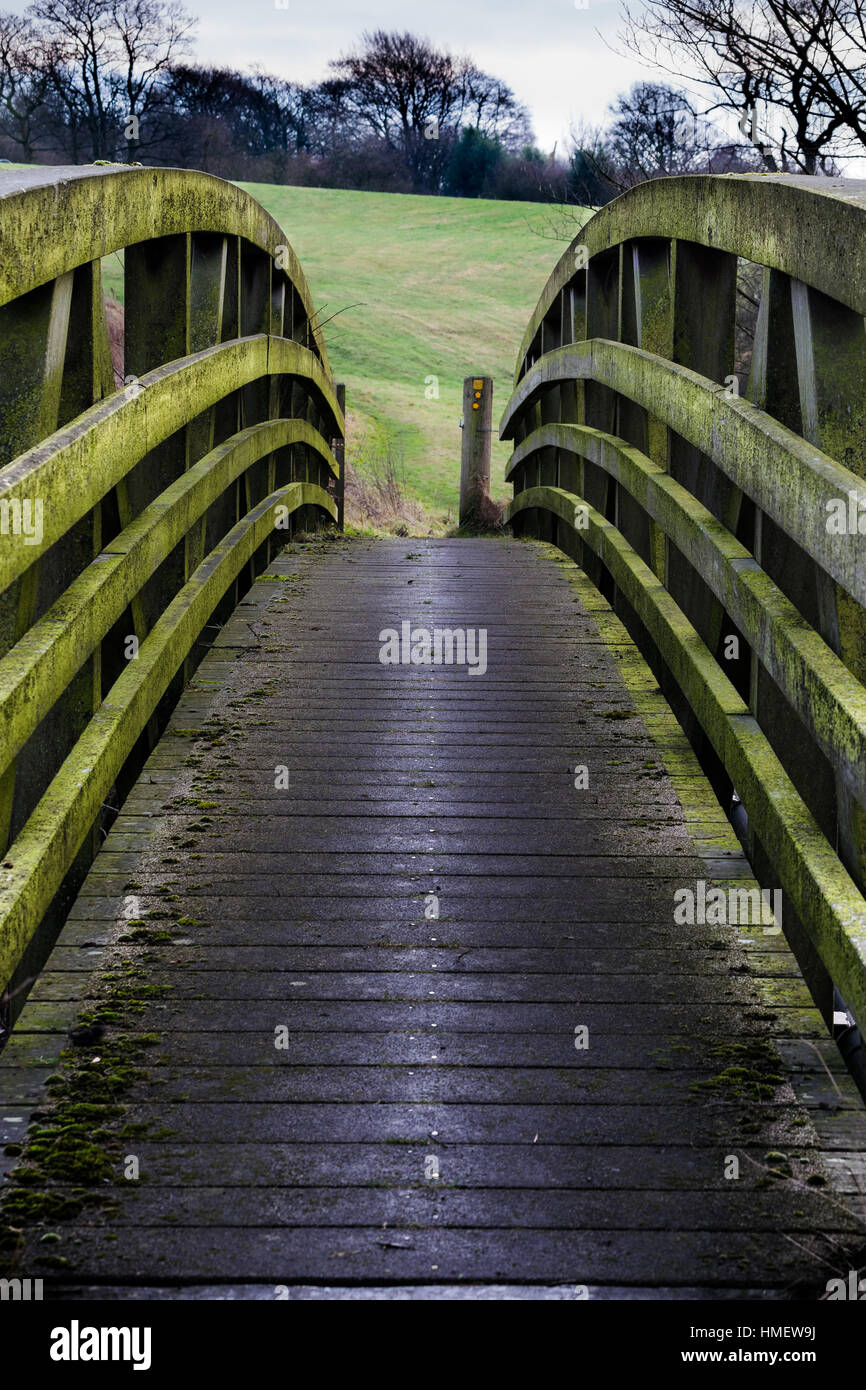 A wooden bridge on a public footpath crossing over a natural brook ...