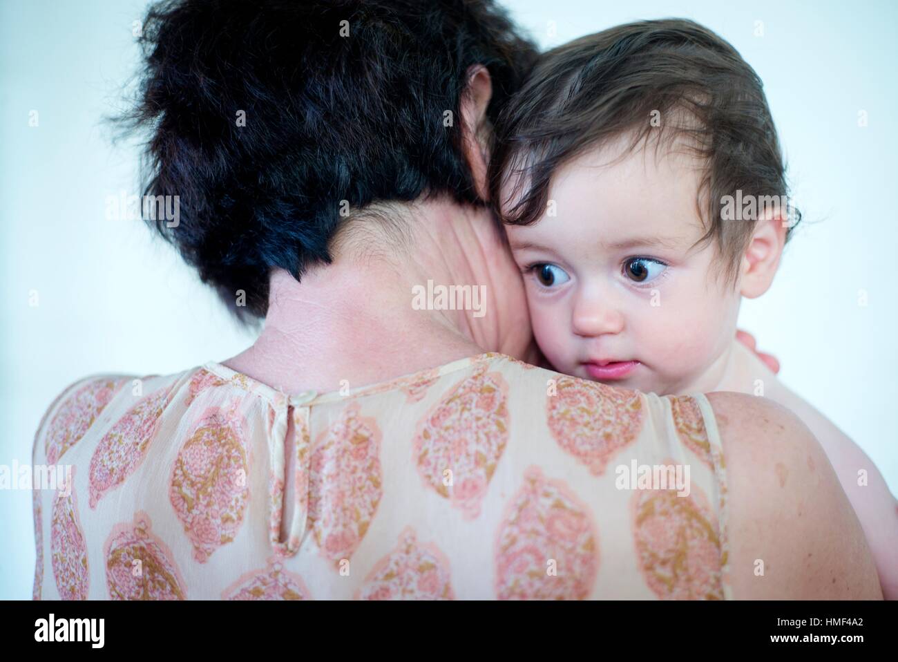 Woman, Grandma, Middle-aged backs with a baby with eyes wide open, in ...