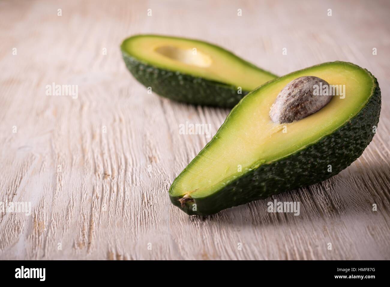 Horizontal photo of single green raw severed avocado which is cut to ...