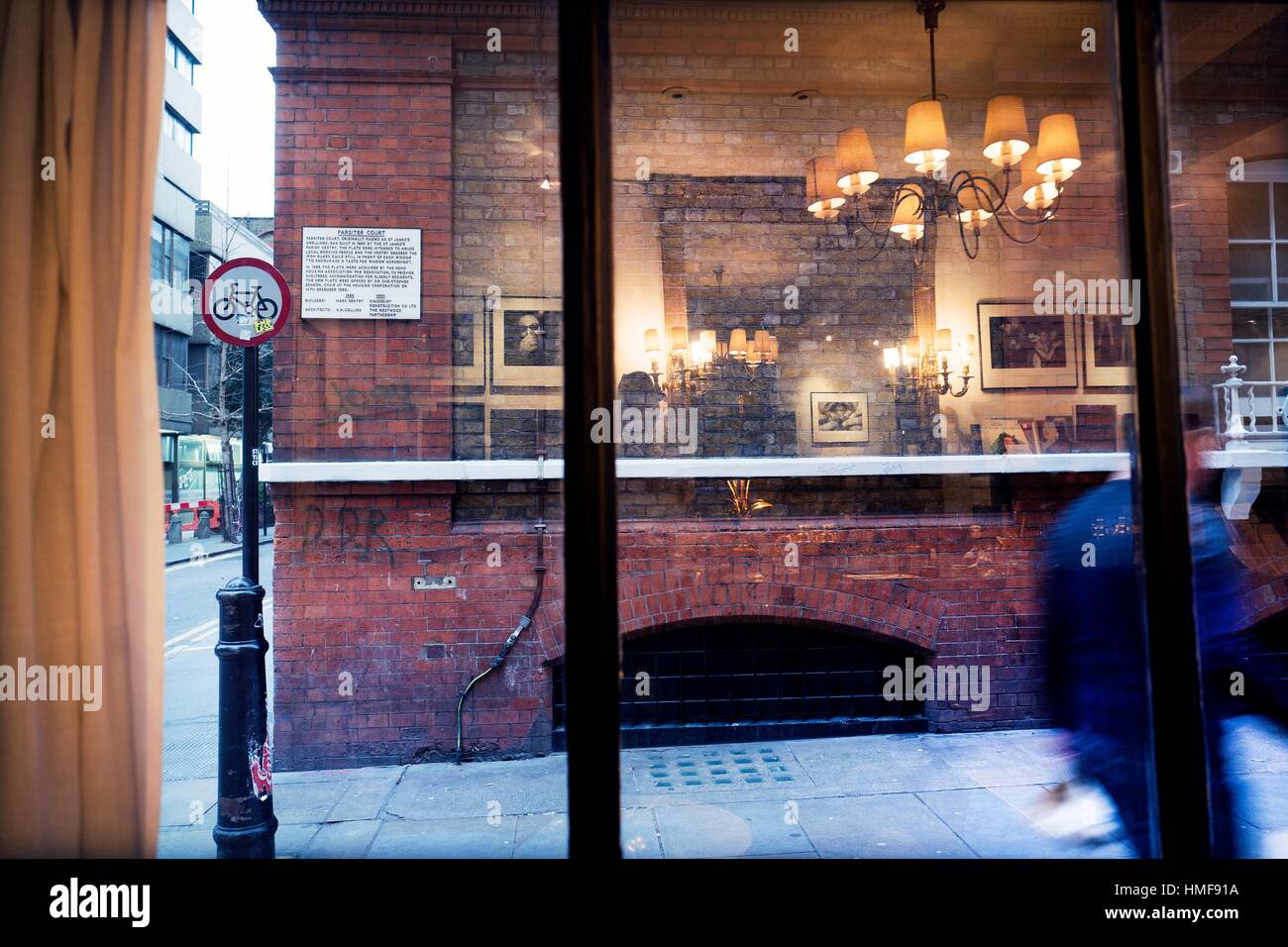 Looking at street view through window. Lamp, furniture and photographs ...