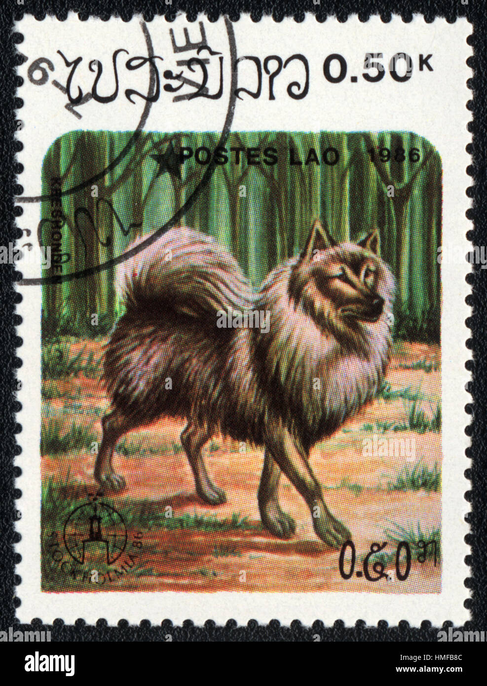A postage stamp printed in Aos shows a Keeshond dog, from series Breeds ...