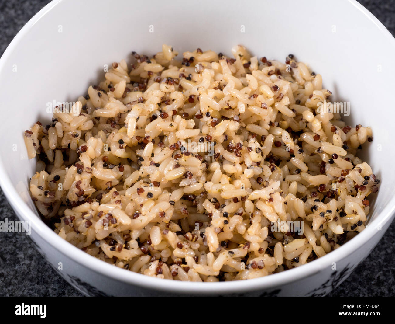A bowl of organic quinoa and wholegrain rice in a kitchen on a black ...