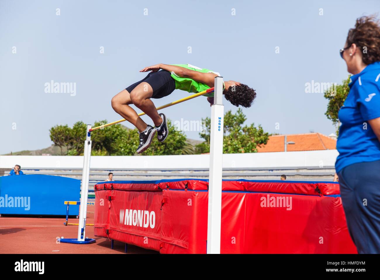 Sports boy performing the high jump on an athletic piste Stock Photo ...