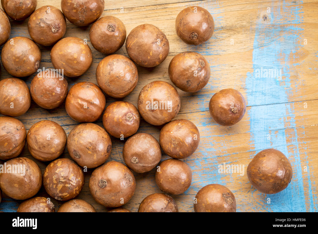 macadamia nuts in shells on a rustic grunge wood - top view Stock Photo ...