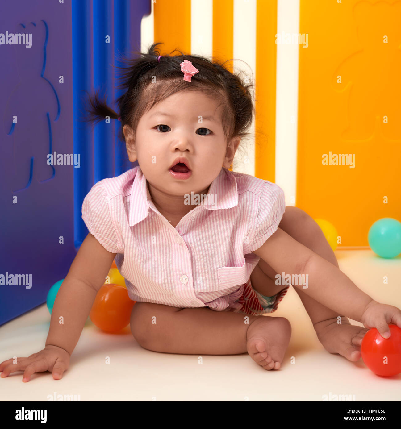 Asian Chinese baby girl playing with colorful balls fenced Stock Photo ...
