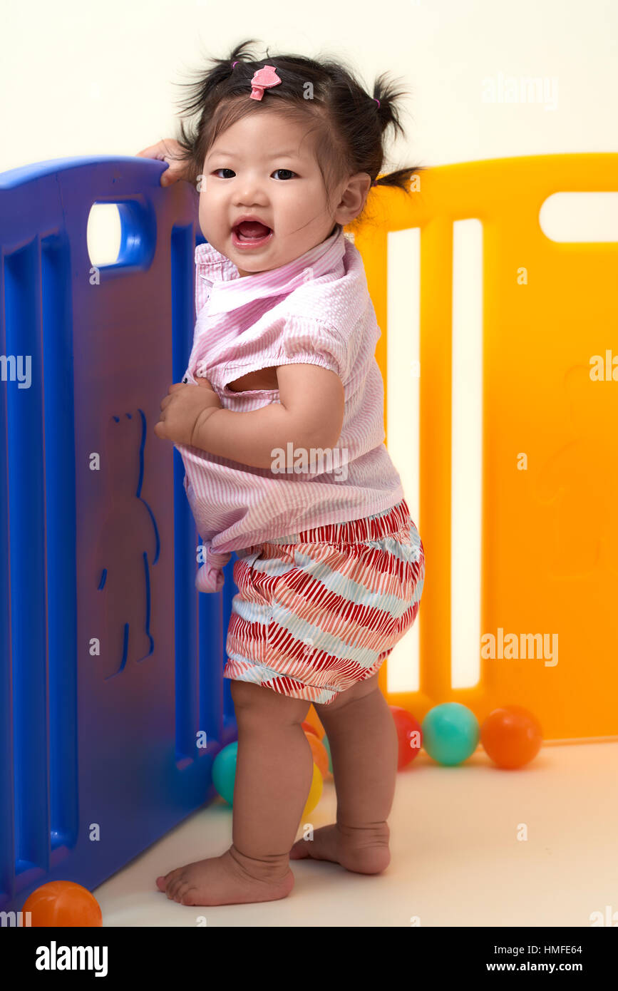 Asian Chinese baby girl playing with colorful balls fenced Stock Photo ...