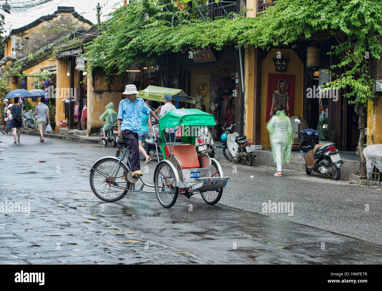 Cyclo driver in the rain, Hoi An, Vietnam Stock Photo - Alamy