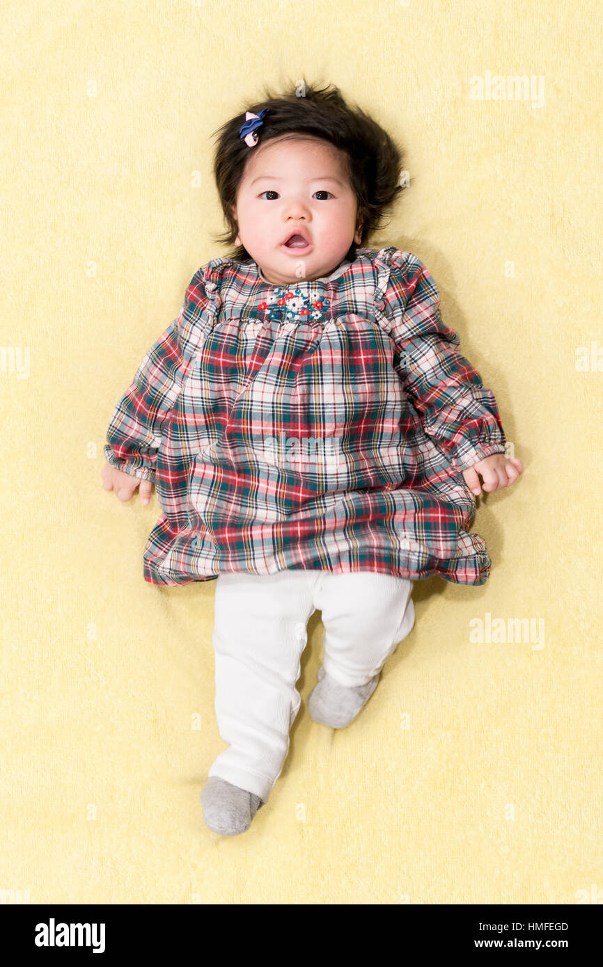 baby girl with cute plaid dress and yellow background Stock Photo - Alamy
