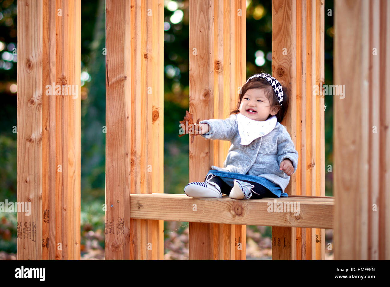 Baby girl sitting on the wood bench in the park Stock Photo - Alamy