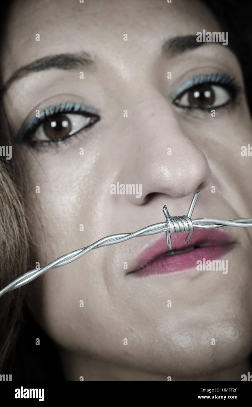 Scared woman behind barbed wire, a conceptual shot on gender violence ...