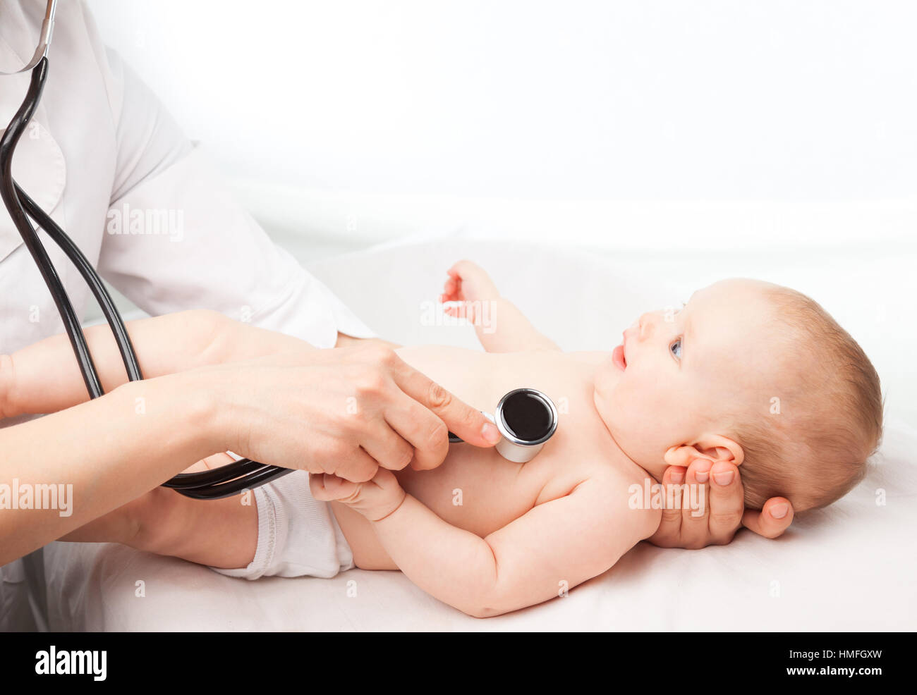 Close-up shot of pediatrician examines three month baby girl. Doctor ...