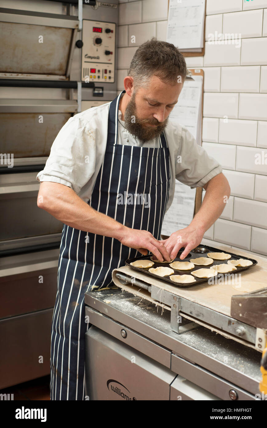 a professional chef prepares and cooks loafs of bread and baking ...