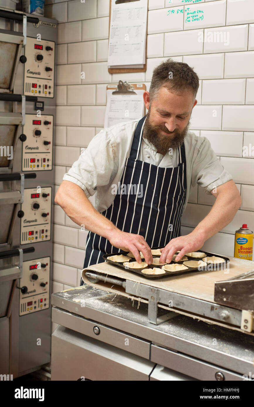 a professional chef prepares and cooks loafs of bread and baking ...