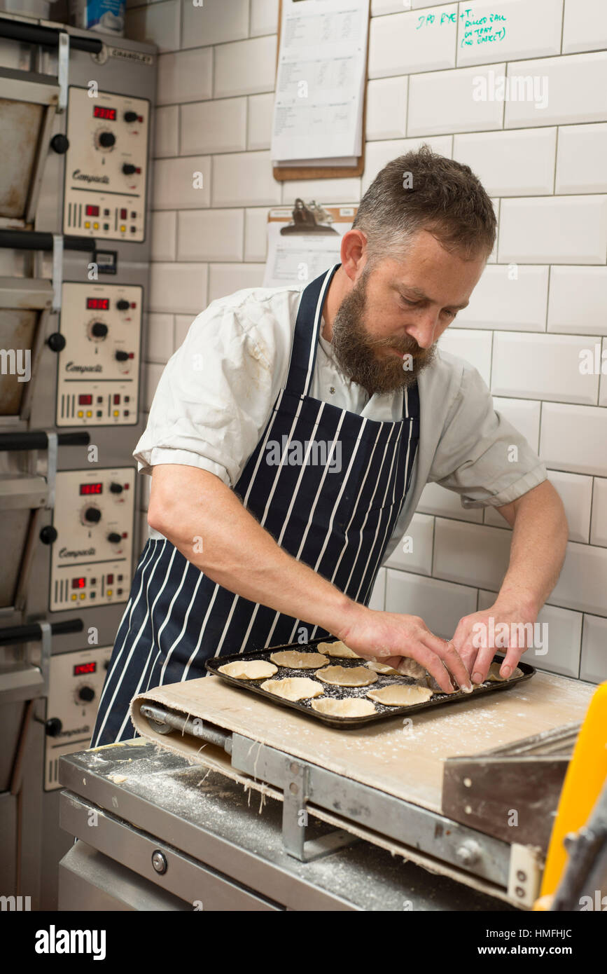 a professional chef prepares and cooks loafs of bread and baking ...