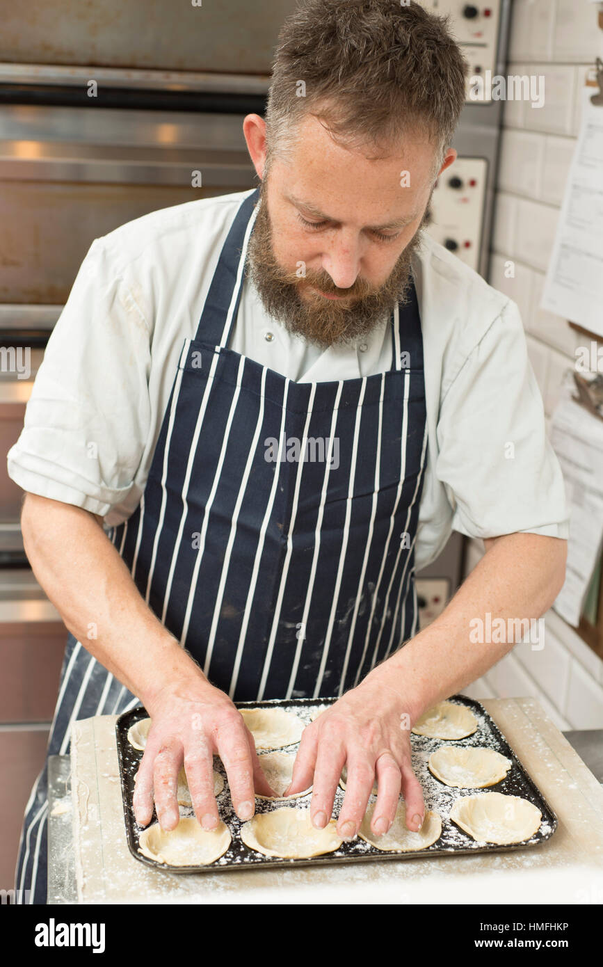 a professional chef prepares and cooks loafs of bread and baking ...