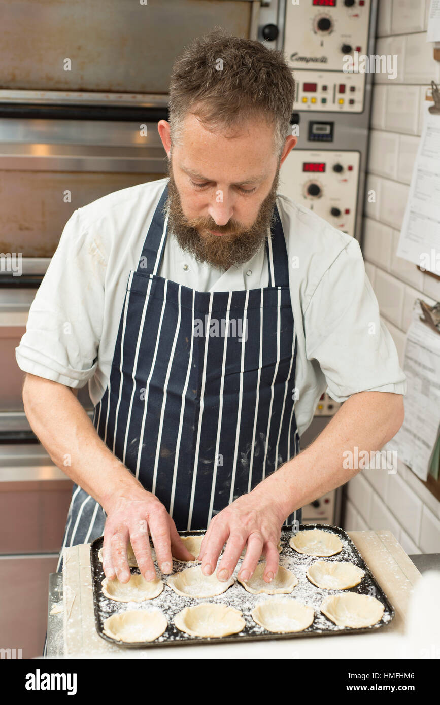 a professional chef prepares and cooks loafs of bread and baking ...