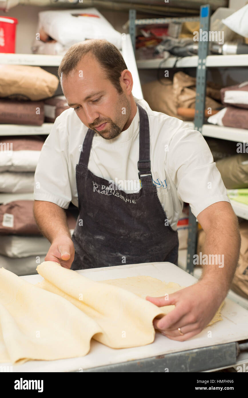 a professional chef prepares and cooks loafs of bread and baking ...