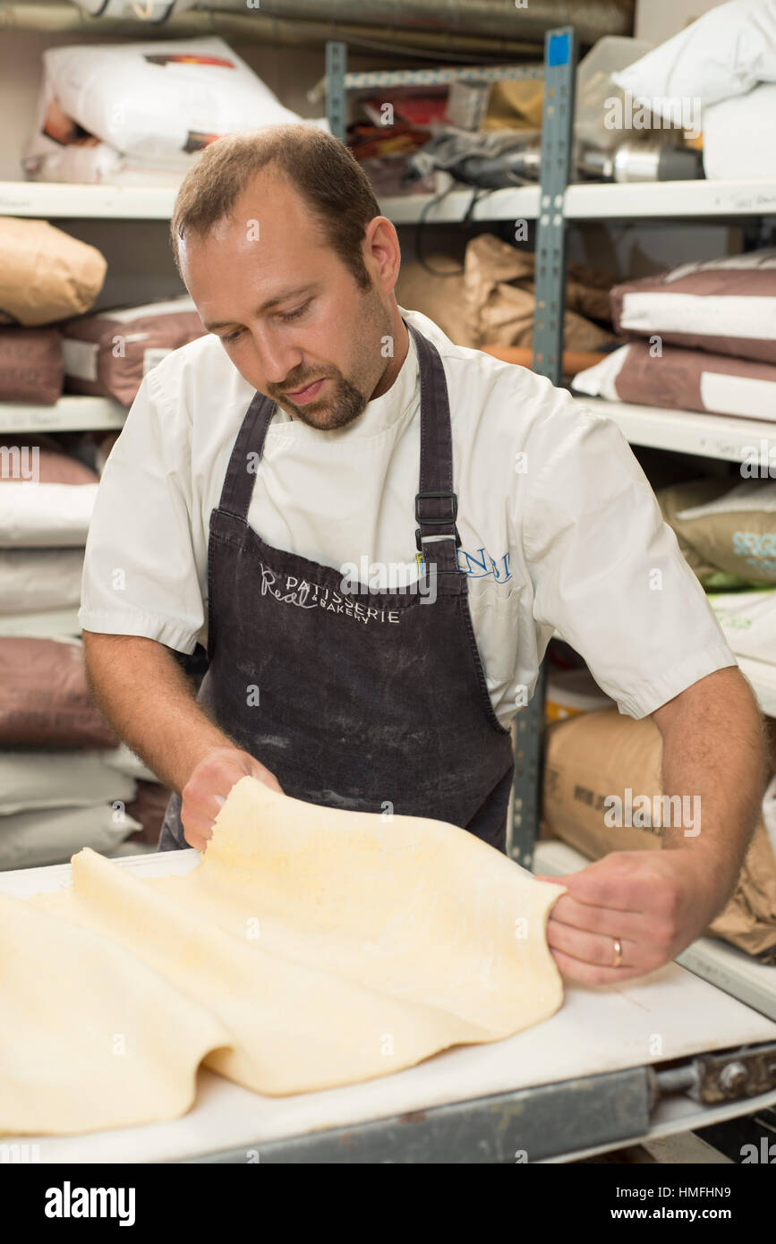 a professional chef prepares and cooks loafs of bread and baking ...