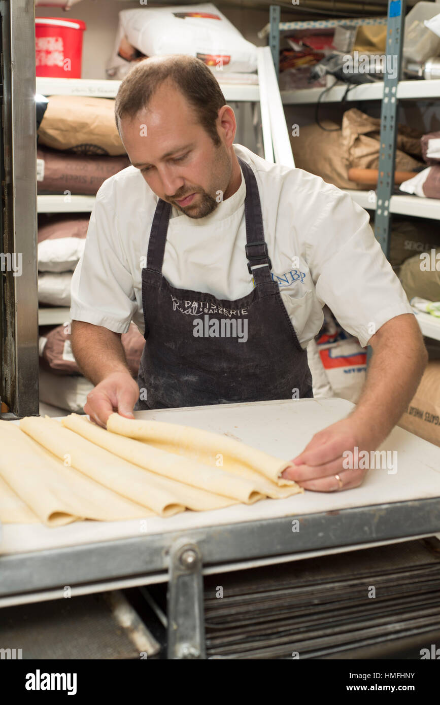 a professional chef prepares and cooks loafs of bread and baking ...