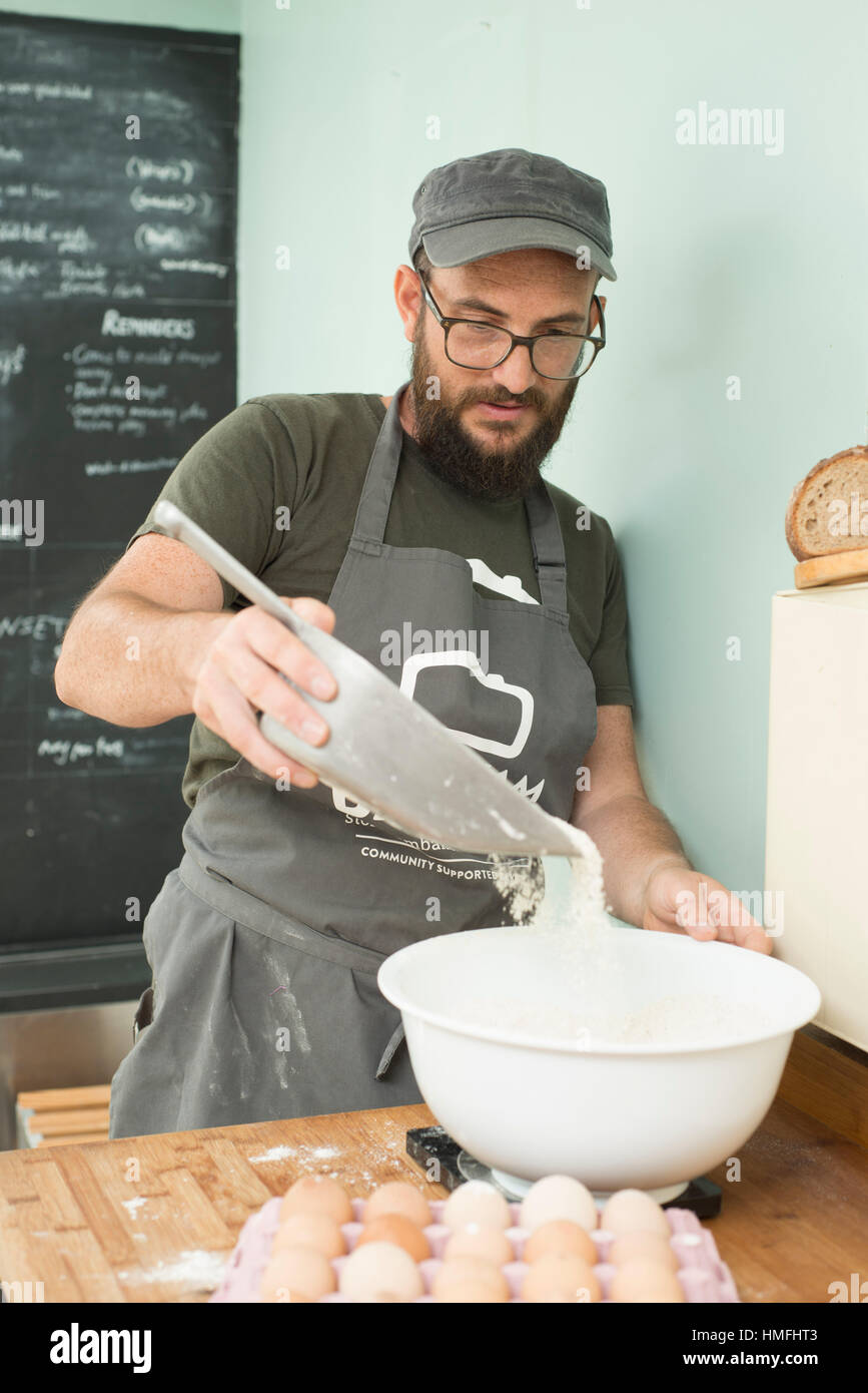 a professional chef prepares and cooks loafs of bread and baking ...