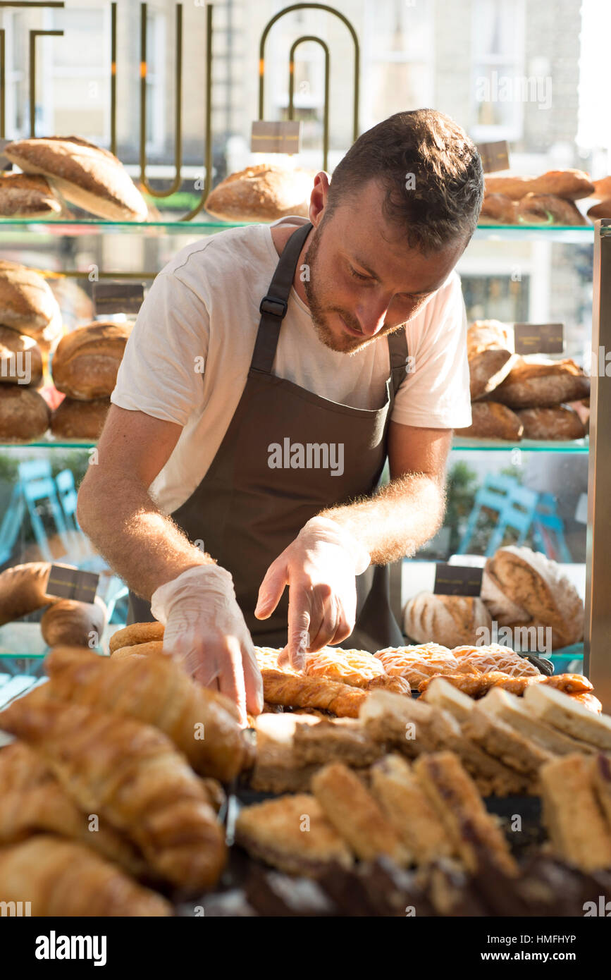 a professional chef prepares and cooks loafs of bread and baking ...