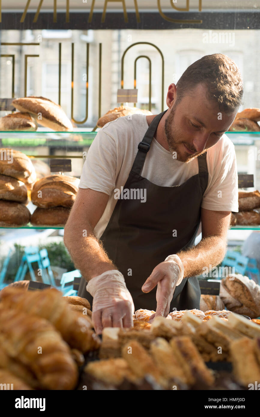 a professional chef prepares and cooks loafs of bread and baking ...