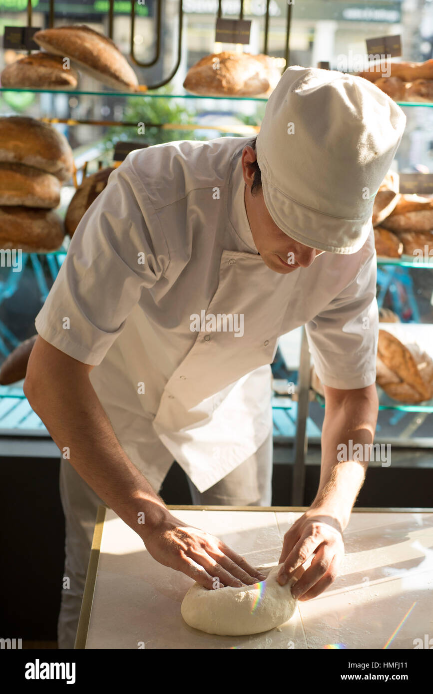 a professional chef prepares and cooks loafs of bread and baking ...