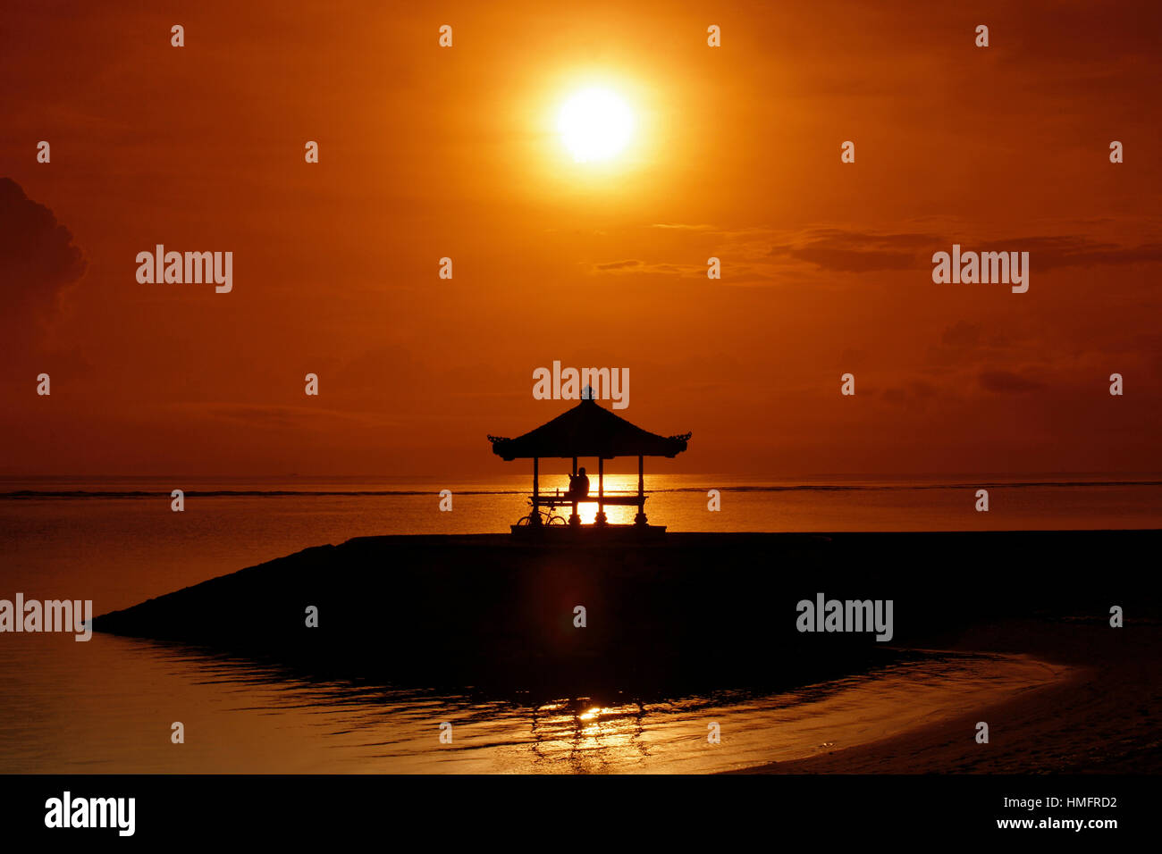 Man sitting and watching the sunset on the beach in Bali Stock Photo ...
