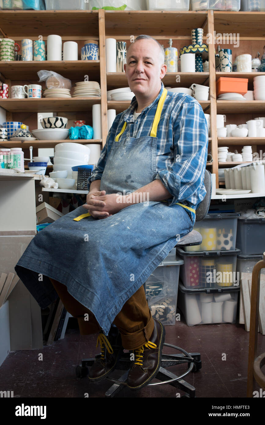 portrait of an artist sitting in their creative art studio shot for a ...