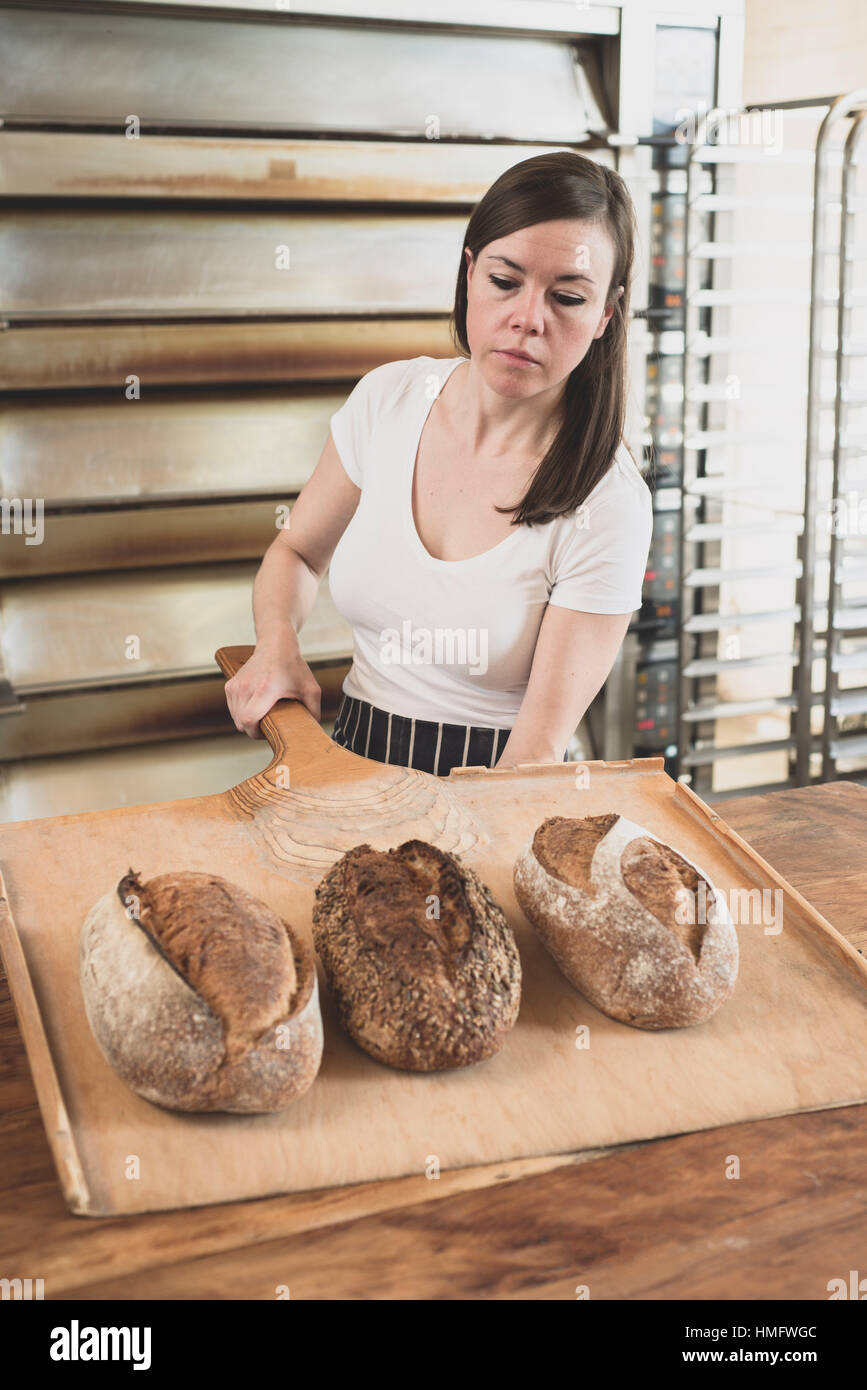 a professional chef prepares and cooks loafs of bread and baking ...