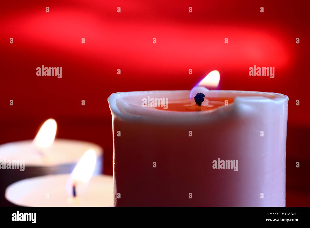 Flames of burning wax candles isolated on a red background Stock Photo ...